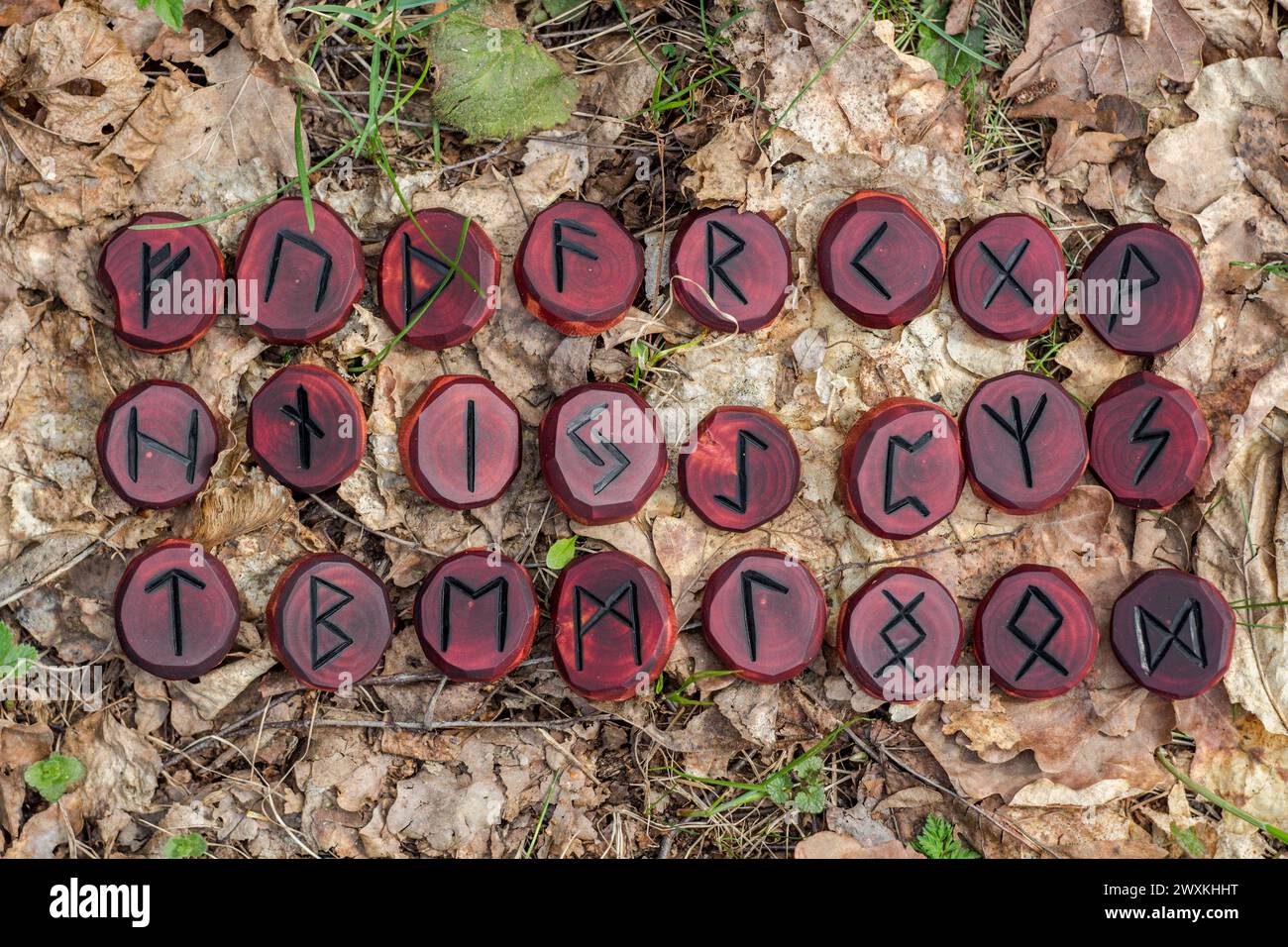 Red runes carved from wood on the ground Stock Photo - Alamy