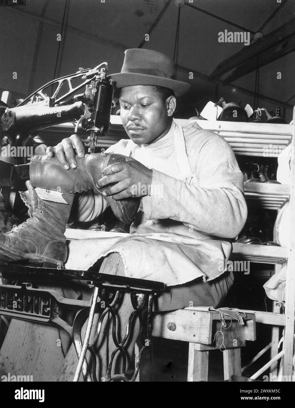 Howard Wilson operating the sewing machine in the C. & E. Shoe Shop at ...