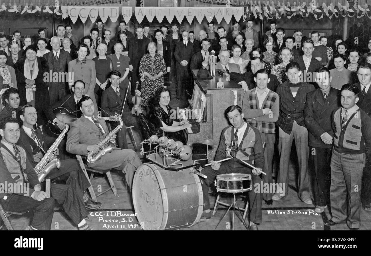 Men and women at a banquet pose for a photo with the band / orchestra ...