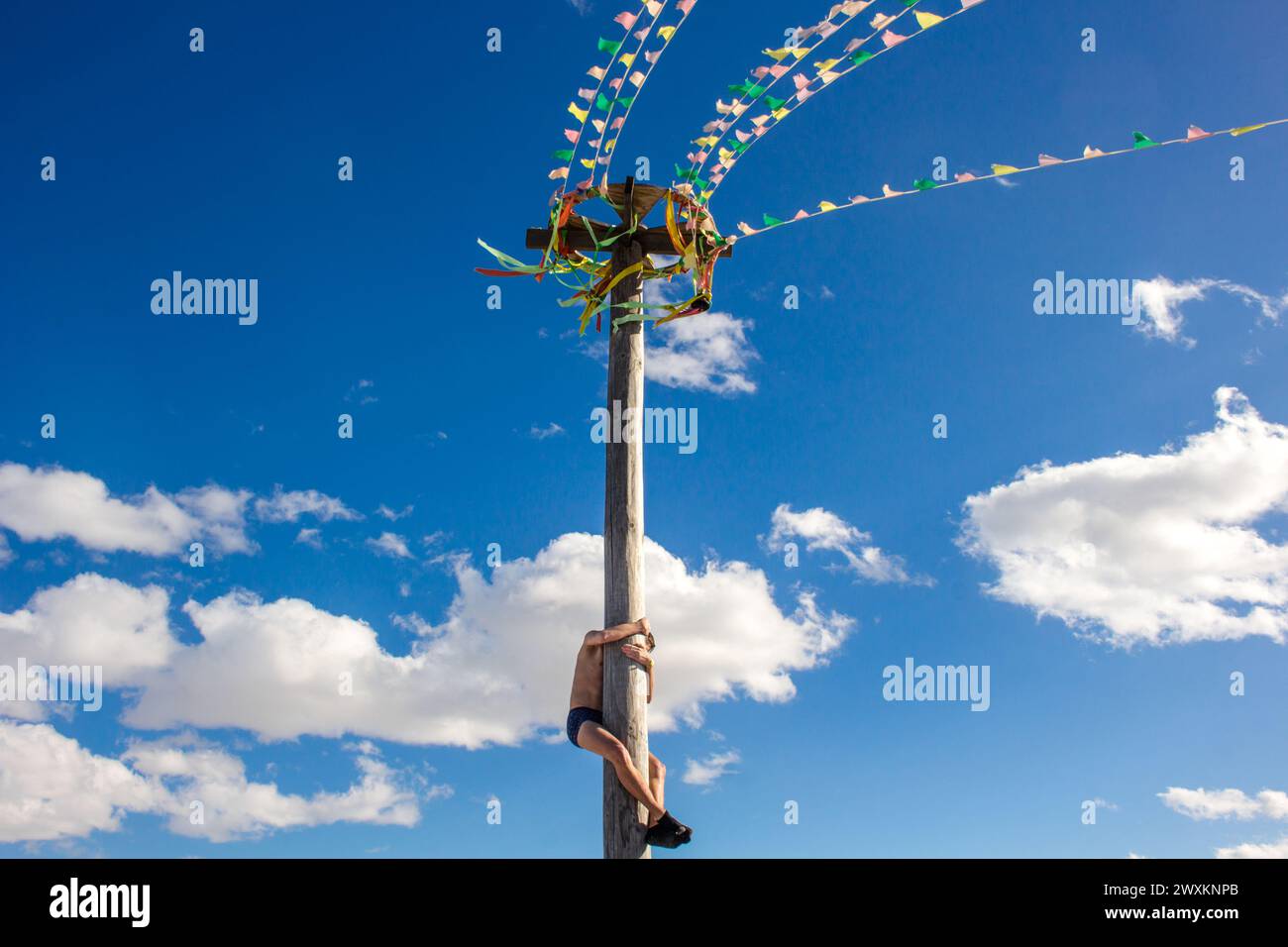 A man climbs onto a pole. Traditional Russian fun at the celebration of ...