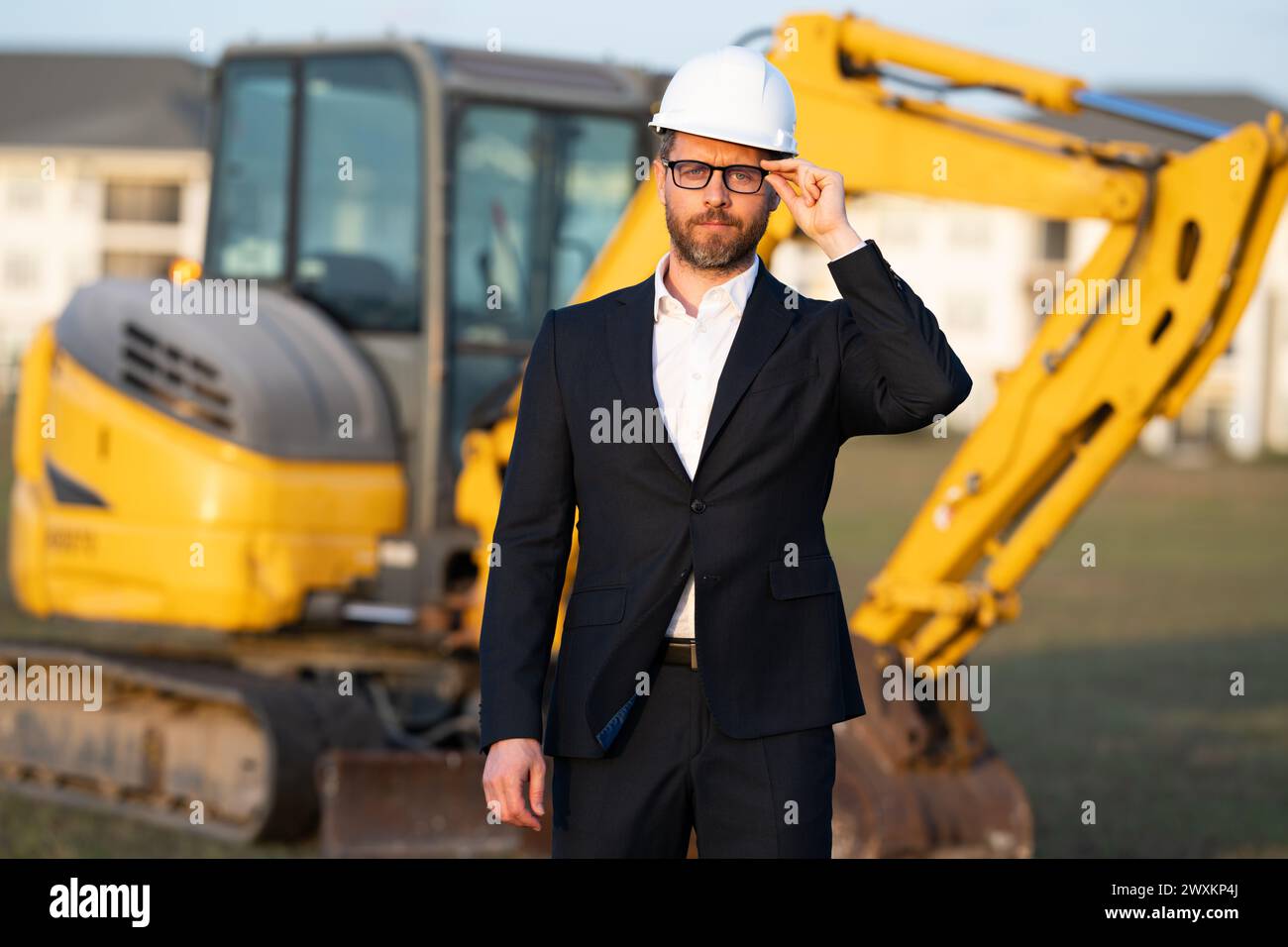 Architect at a construction site. Architect man in helmet and suit at ...