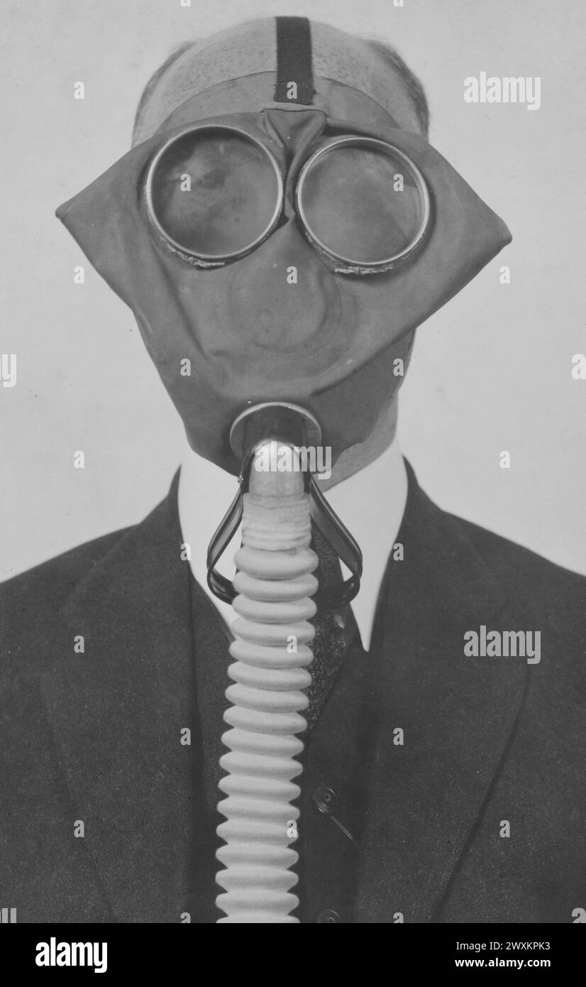 Front view of a man wearing a standard American gas mask with a British ...