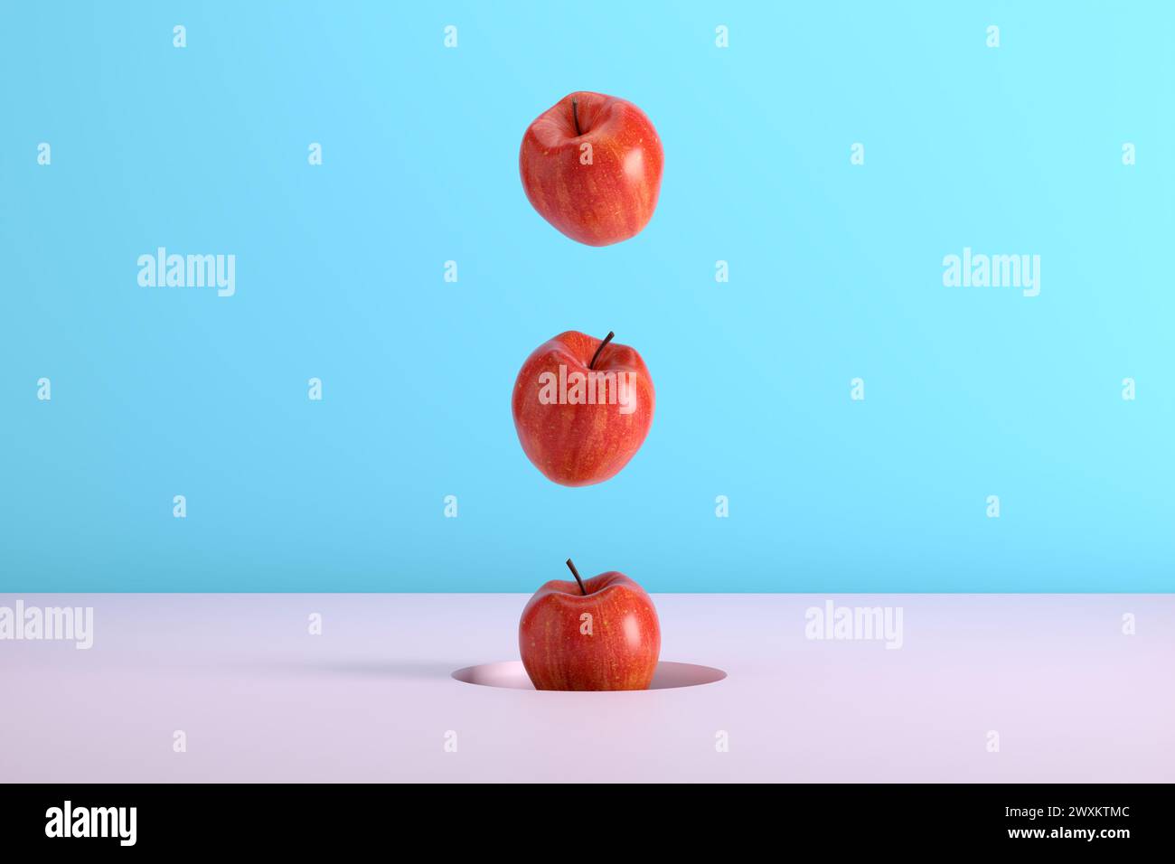 Red apples falling from a hole on blue and pink colored background ... Red apples falling from a hole on blue and pink colored background ...