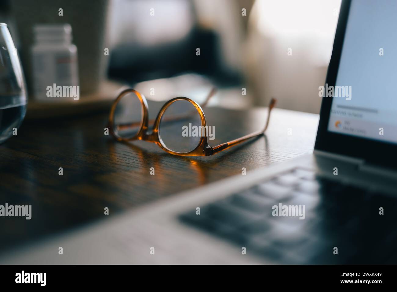 Workspace with laptop, glasses, and wine glass on desk Stock Photo - Alamy