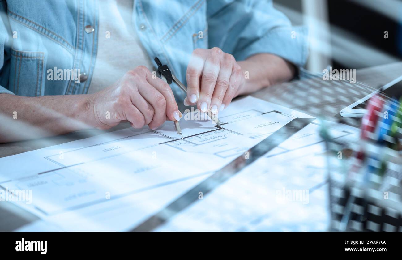 Female architect working on blueprint of new construction project ...