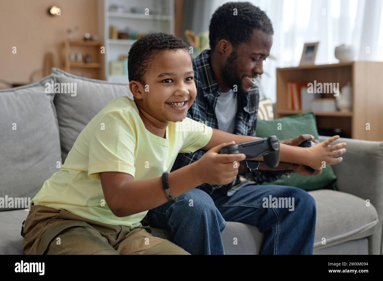 Side view portrait of smiling young boy playing competitive video game ...