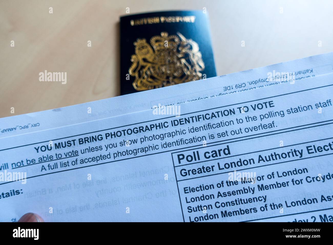 UK poll card with photo ID passport in background Stock Photo - Alamy