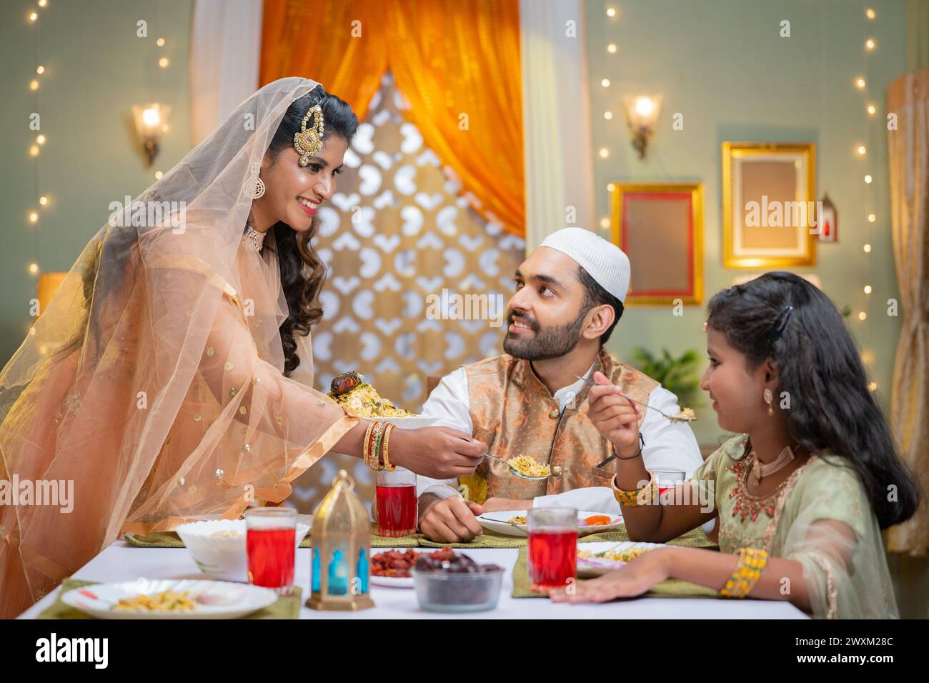 Happy smiling muslim woman serving chicken biryani to husband during ...