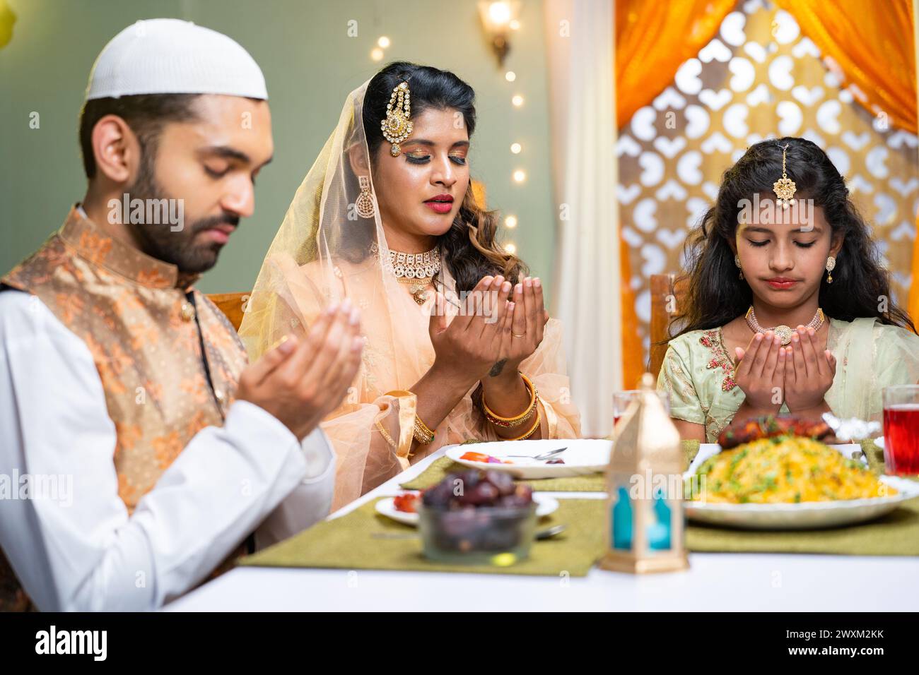 Indian Muslim family with kid praying at ramadan iftar dinner before ...