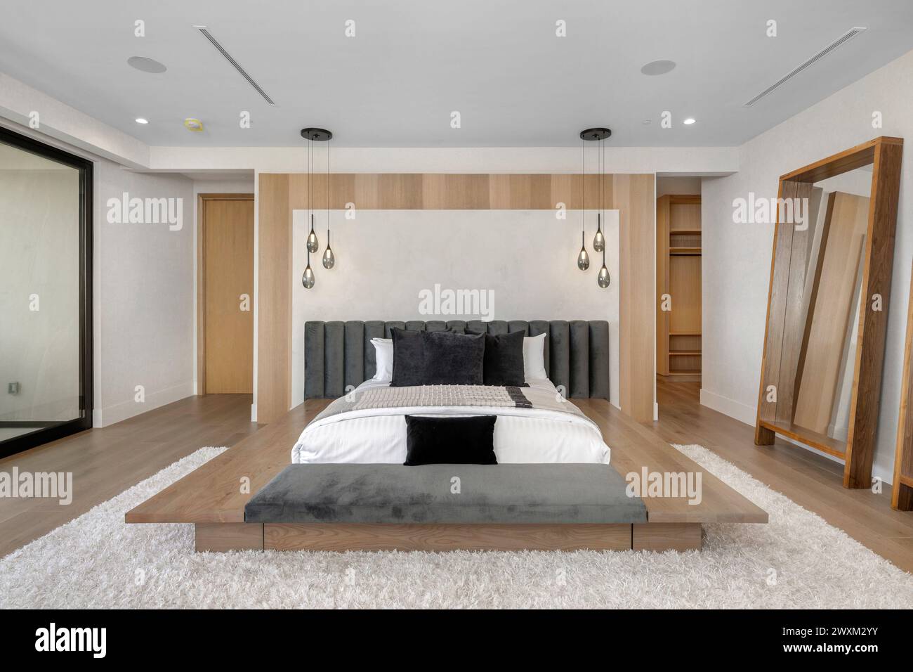 An interior of a bedroom featuring a spacious bed and wooden flooring ...
