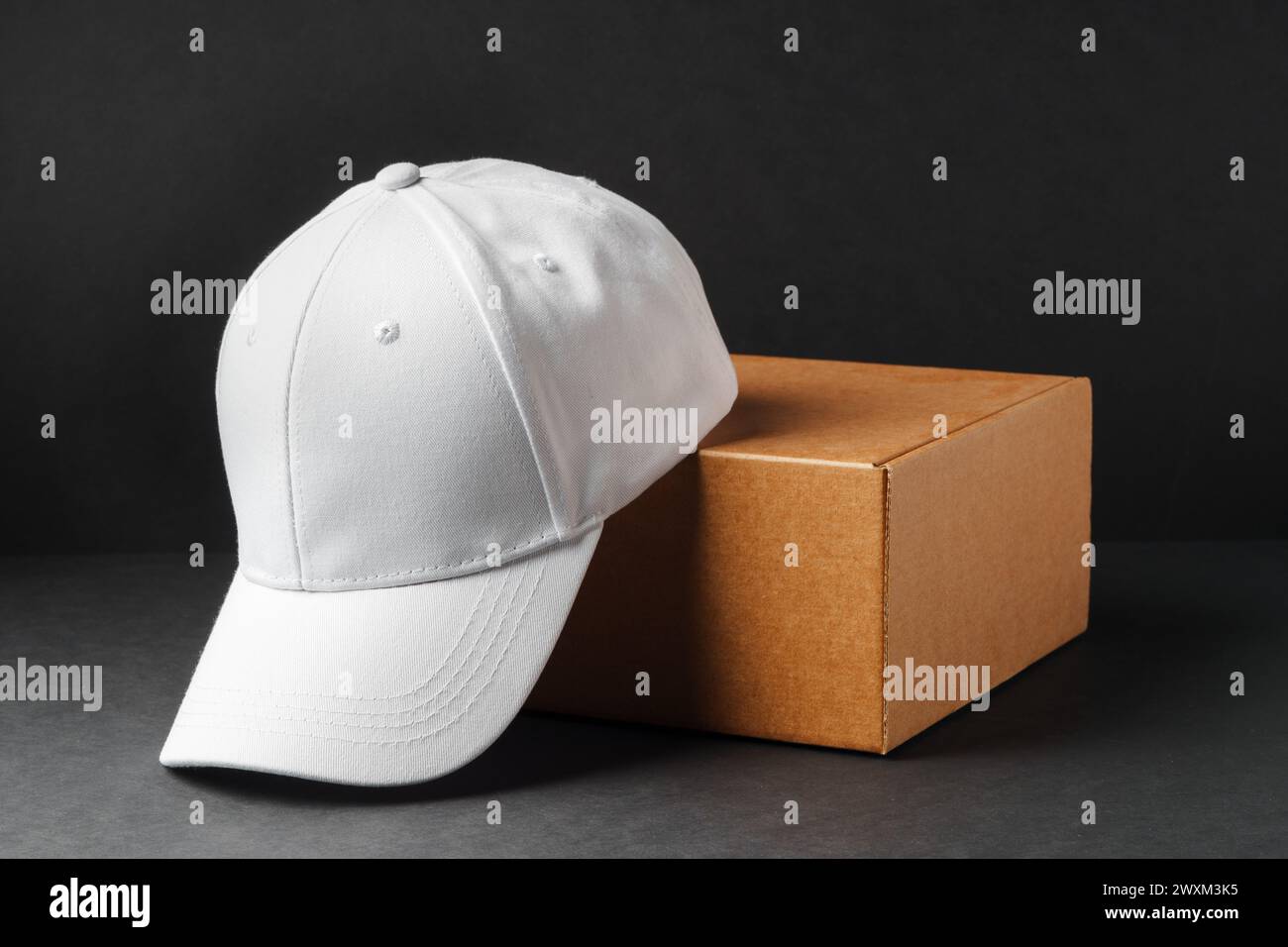 White Baseball Cap Beside Cardboard Box Stock Photo - Alamy