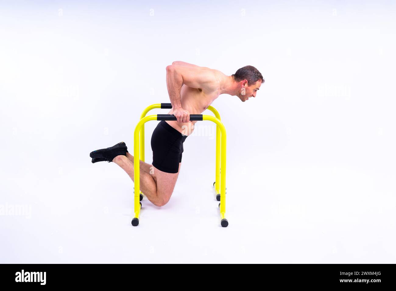 Male gymnast performing handstand on parallel bars, studio shot Stock ...
