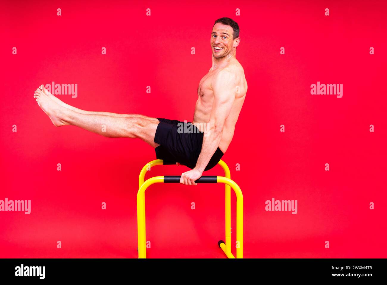 Male gymnast performing handstand on parallel bars, studio shot Stock ...