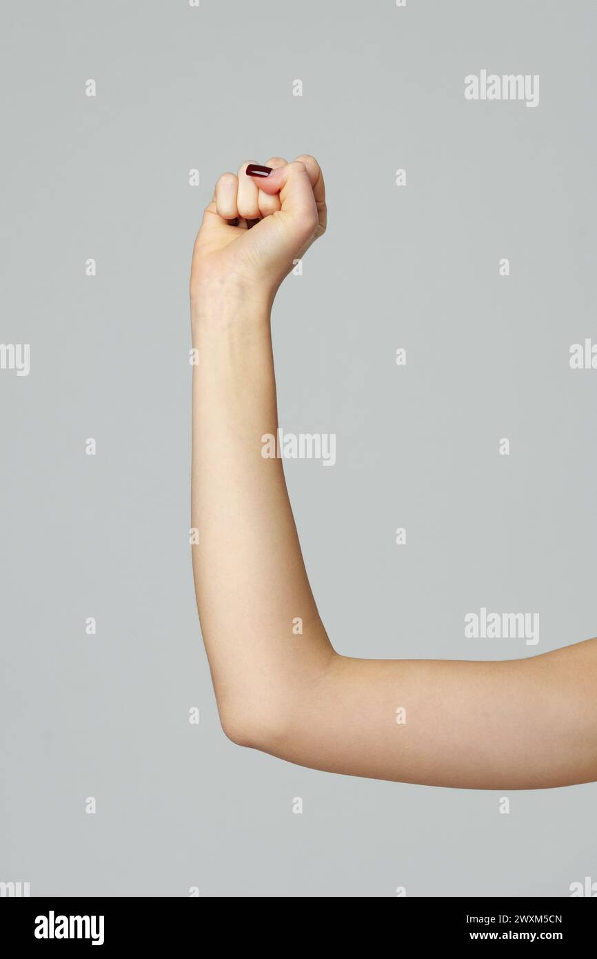 Female hand with clenched fist on gray background Stock Photo - Alamy