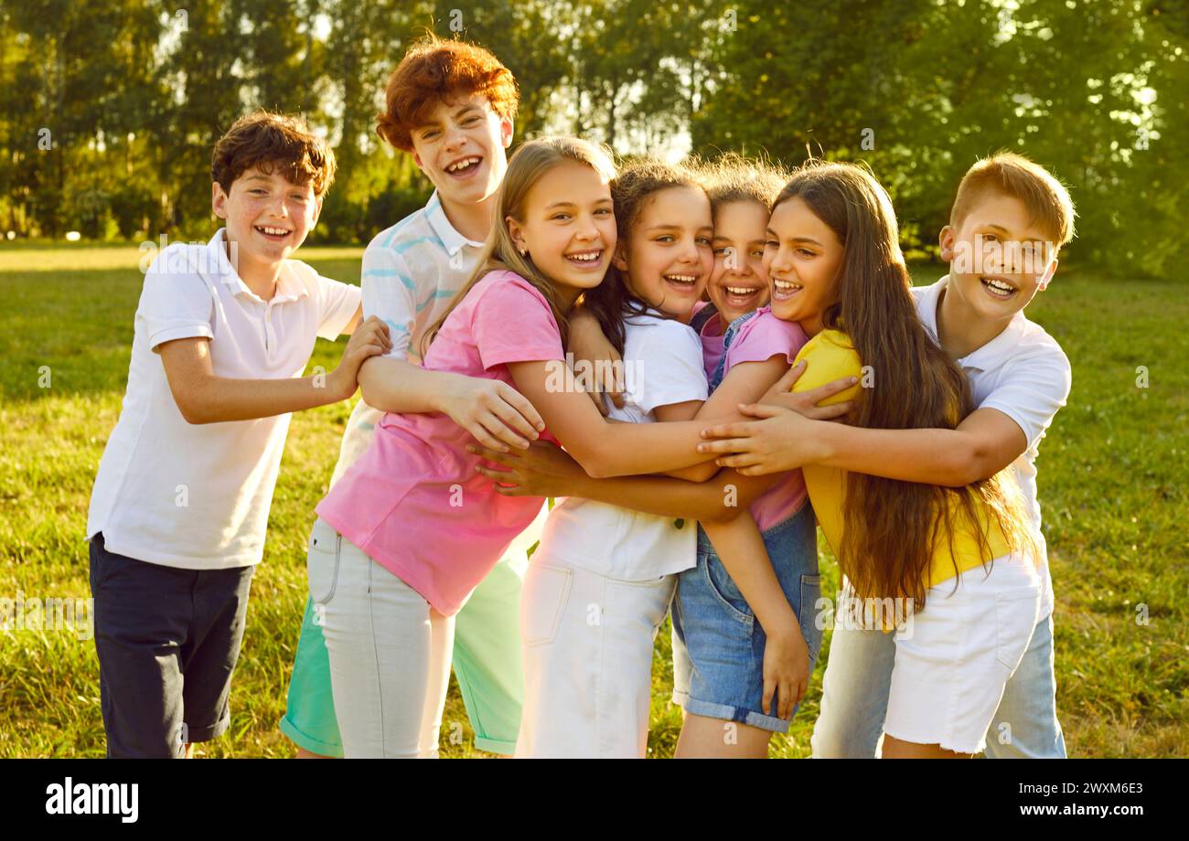 Happy smiling kids standing in the summer park in nature together and ...