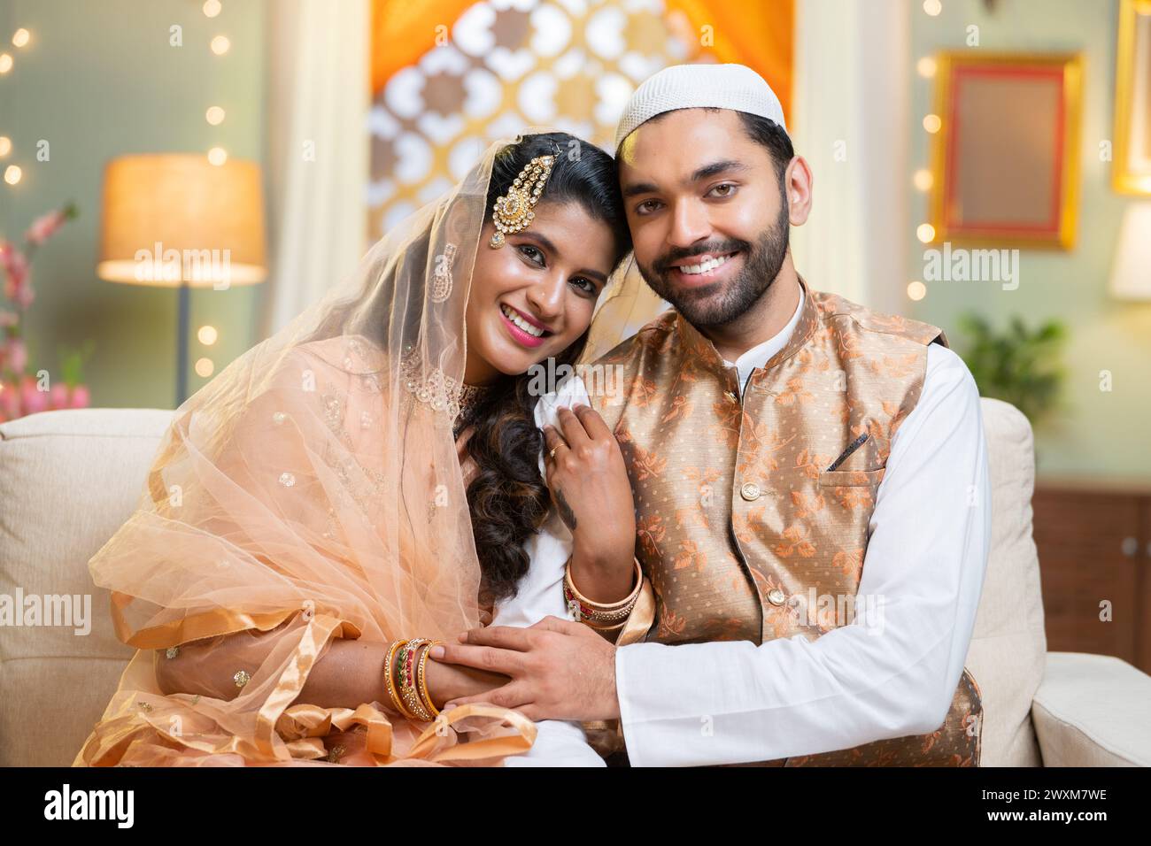 Happy smiling indain Muslim couple embracing by looking at camera while ...