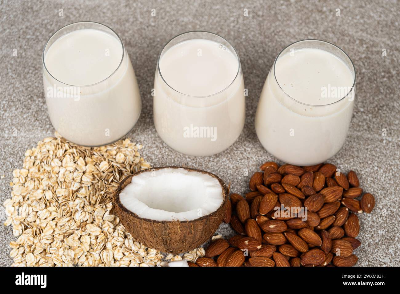 Types of plant-based milk in glasses. Oat, coconut and almond milk ...