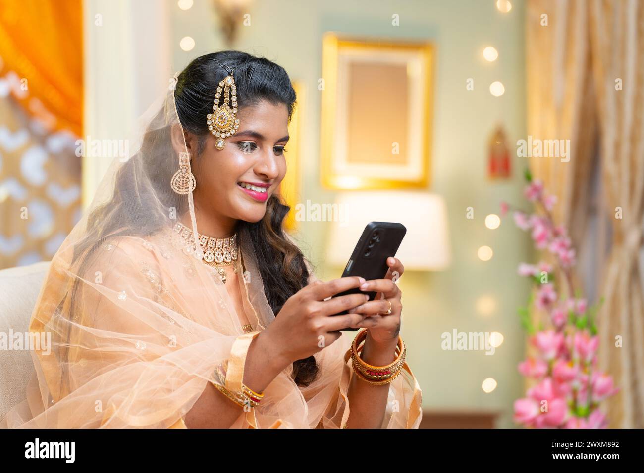 Happy indian muslim woman busy by using social media or watching videos ...