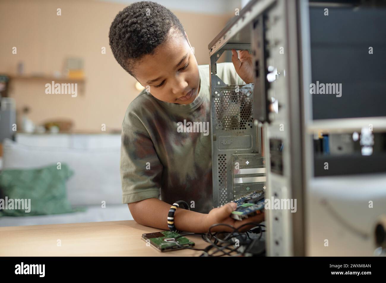 Portrait of young African American boy building PC computer and ...