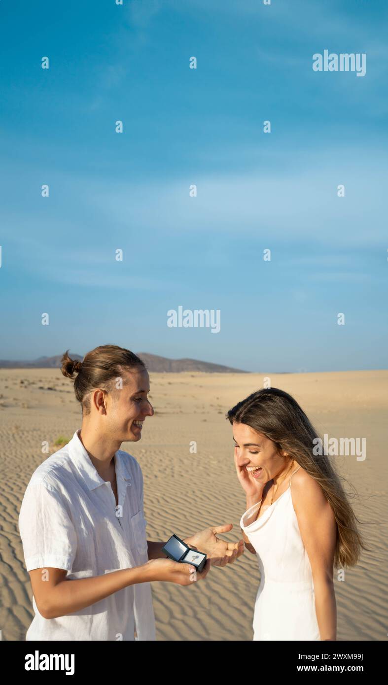 A beautiful and romantic beach proposal moment with a happy couple ...