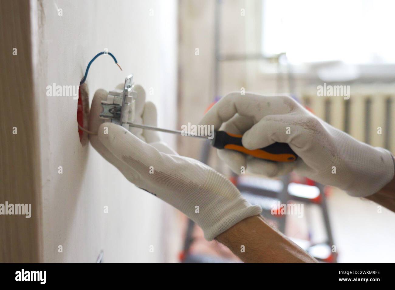 Installation of electric household socket on the wall during the ...