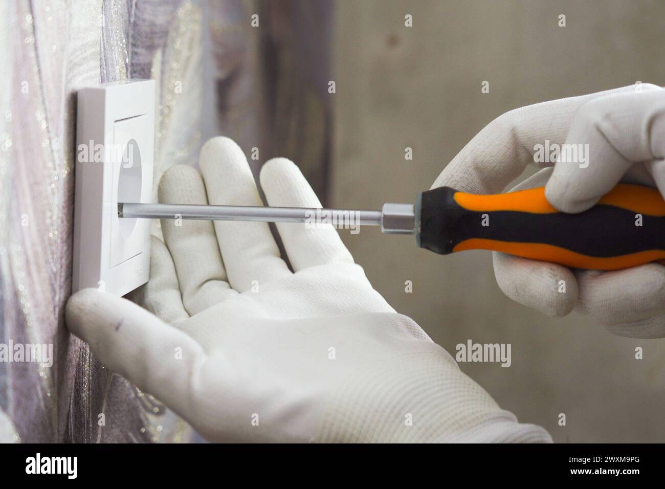 Installation of electric household socket on the wall during the ...