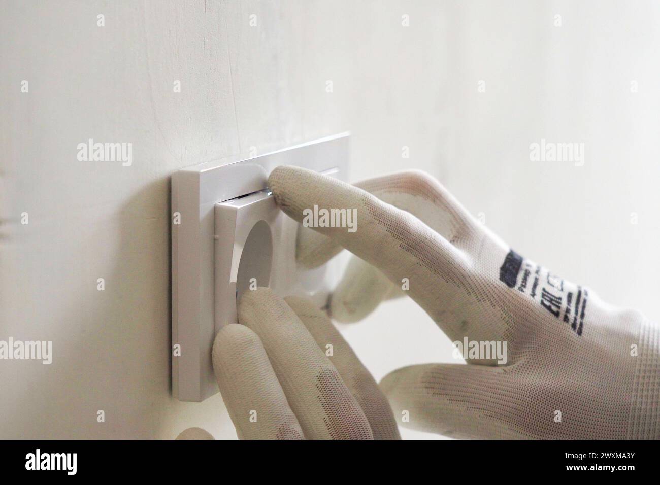 Installation of electric household socket on the wall during the ...