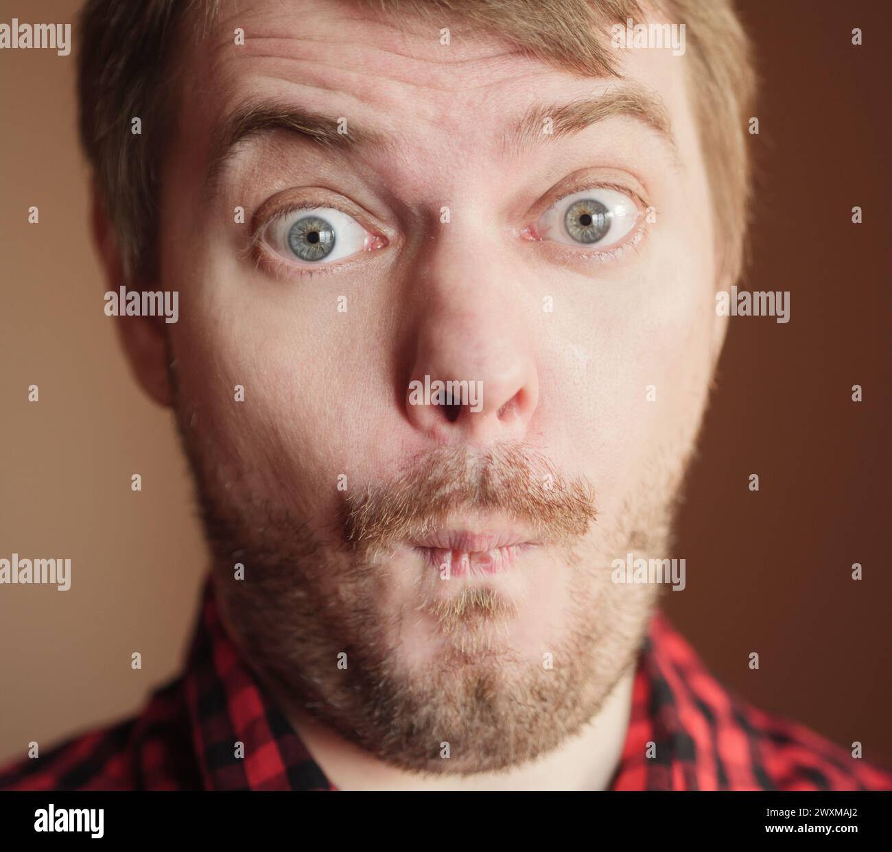 Man with surprised face. Portrait on the beige background Stock Photo ...