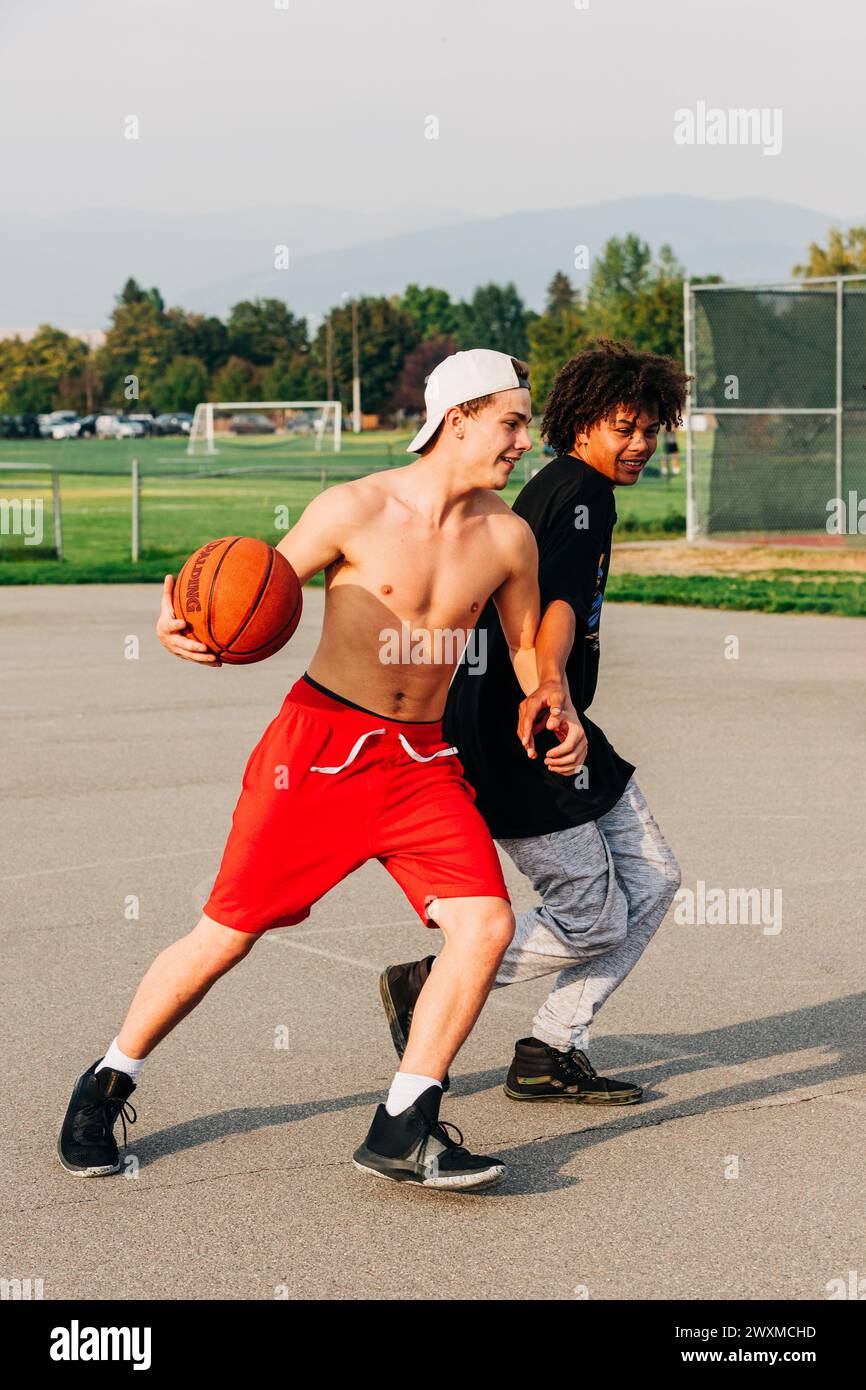 Multicultural boys playing basketball game together Stock Photo - Alamy