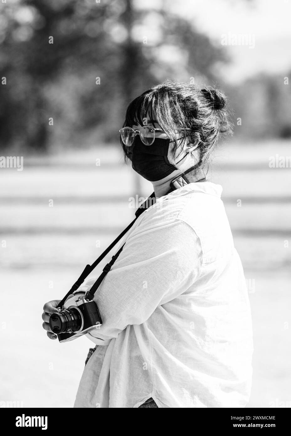 Asian woman wearing glasses with a camera around neck Stock Photo - Alamy