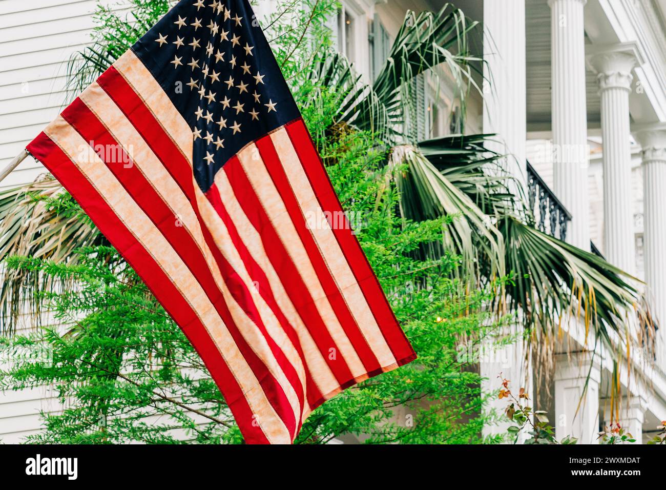 Colonial home with white columns and American flag in New Orleans Stock ...