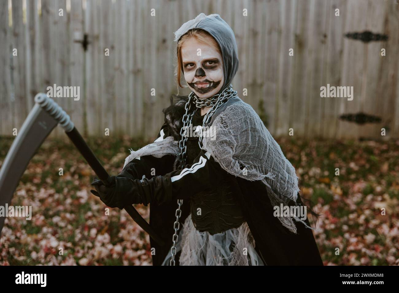 Child in Grim Reaper Halloween Costume in yard with Fall Leaves Stock ...