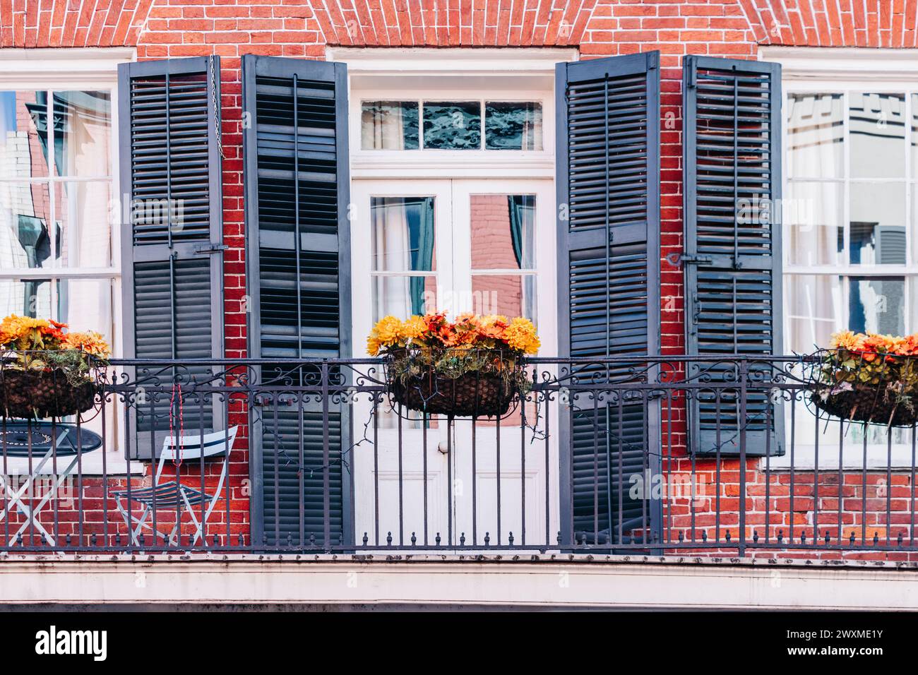 French Quarter brick building patio facade with potted flowers Stock ...