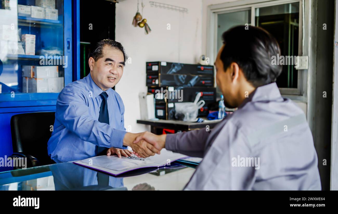 A mechanic discussing car repairment with another person in a garage ...