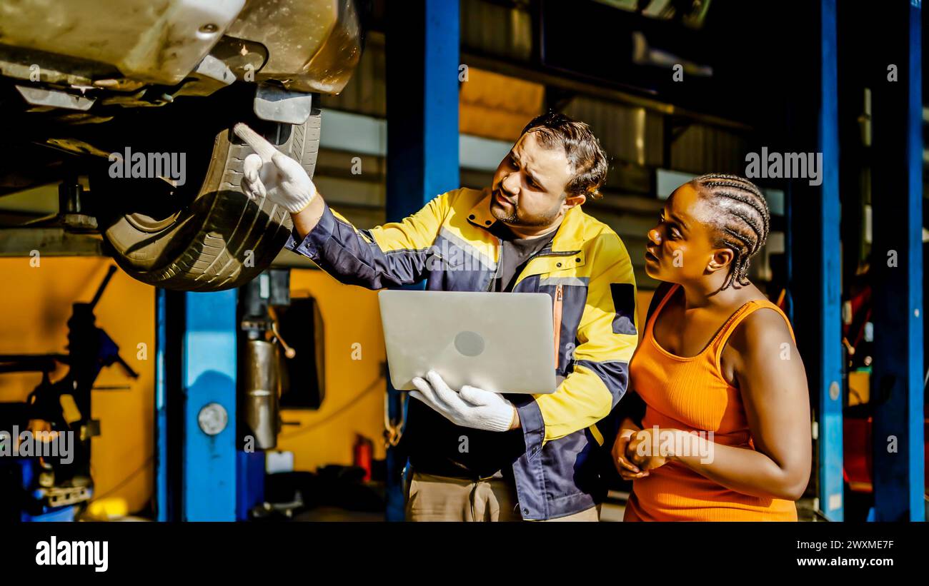 A mechanic discussing car repairment with another person in a garage ...
