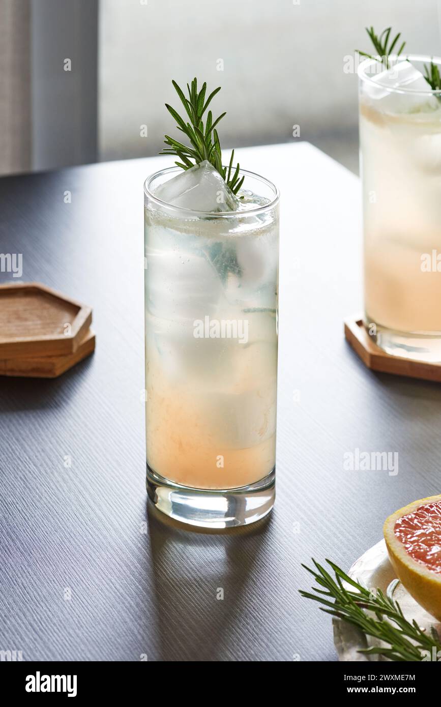 two grapefruit rosemary cocktails with garnish on black table Stock ...