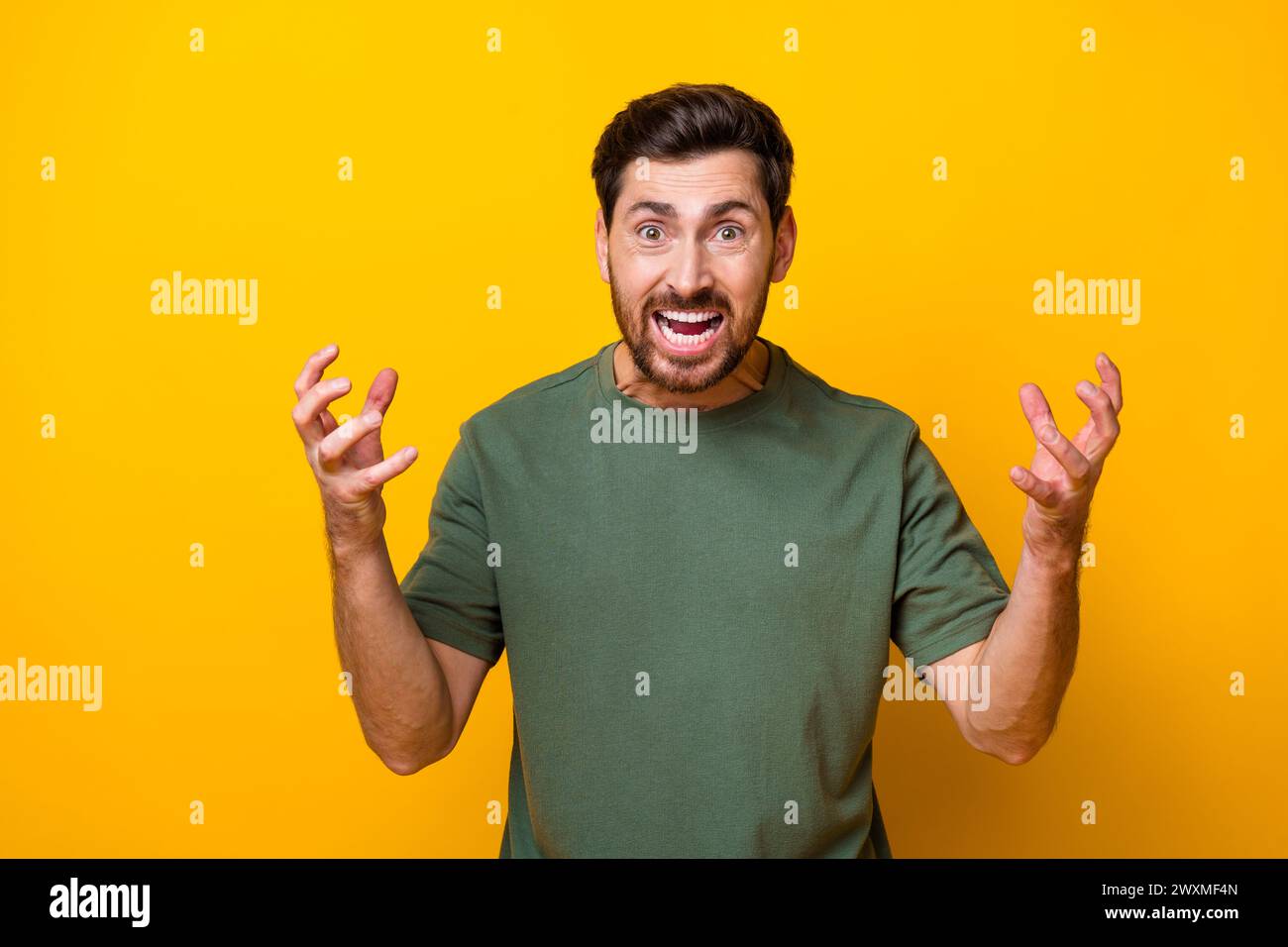 Photo of angry furious guy dressed green t-shirt rising arms hands ...