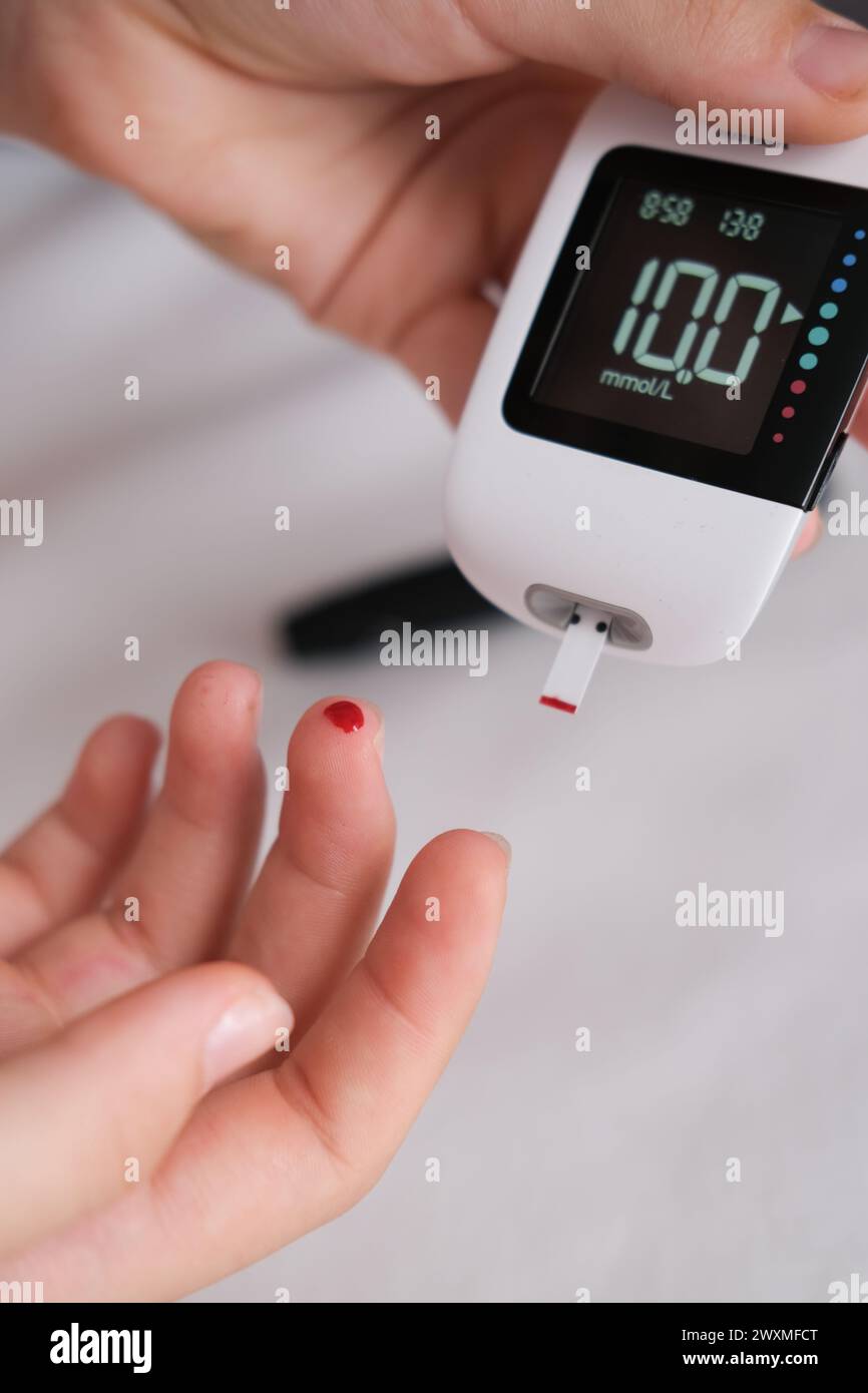 Diabetes test. Child hands checking blood sugar level by Glucose meter ...