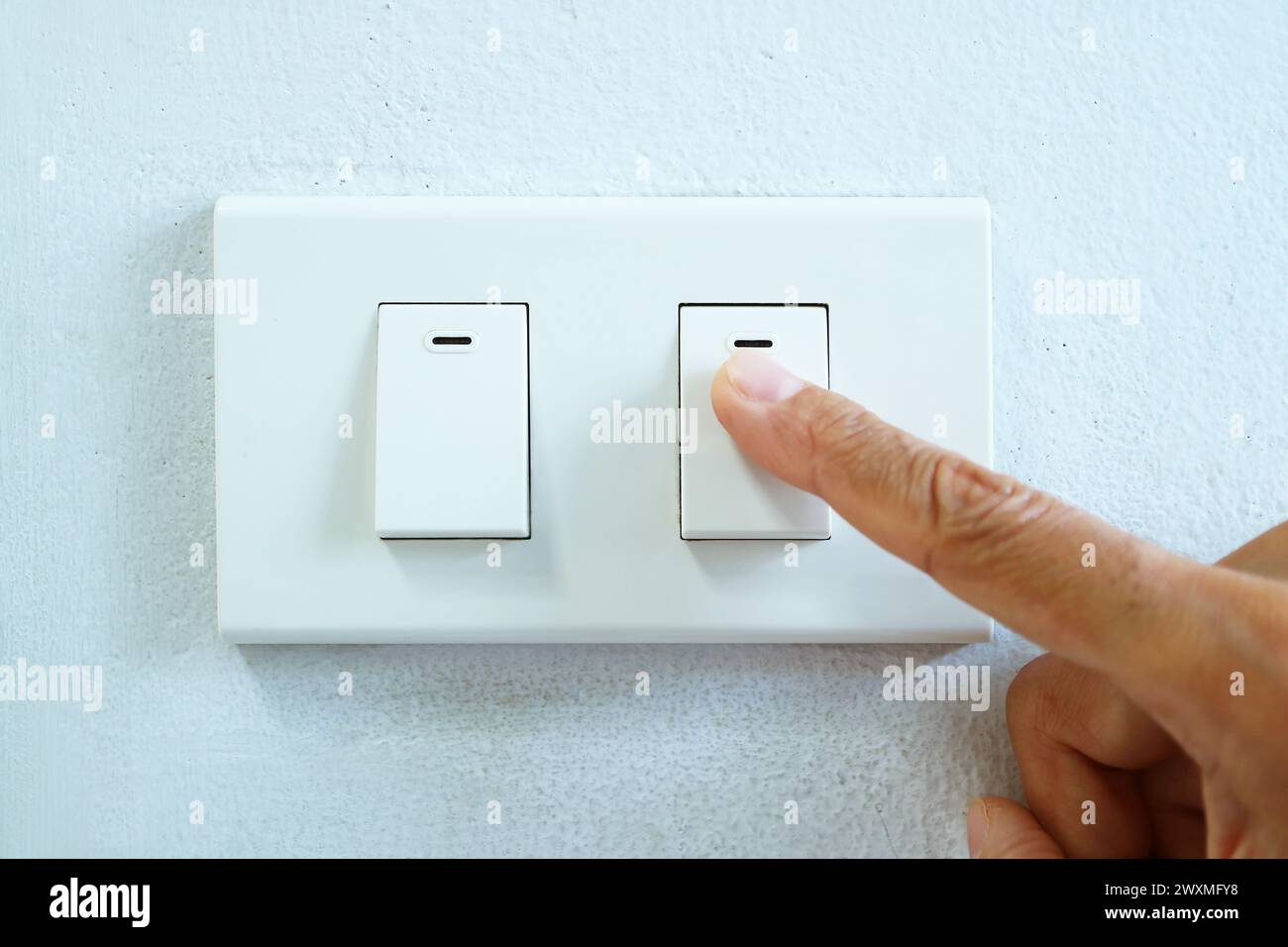 Finger pushing a switch to turn on light Stock Photo - Alamy