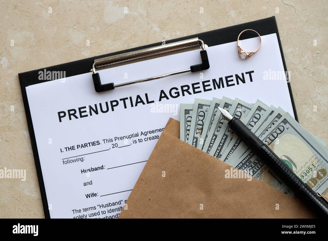 Prenuptial agreement and wedding ring on table. Premarital paperwork ...