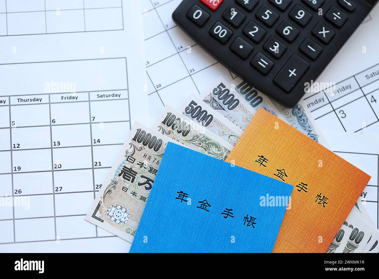 Japanese pension insurance booklets on table with yen money bills and ...