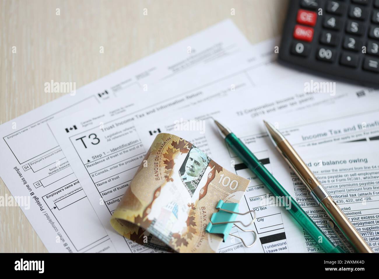 Many blank Canadian tax forms lies on table with canadian money bills ...