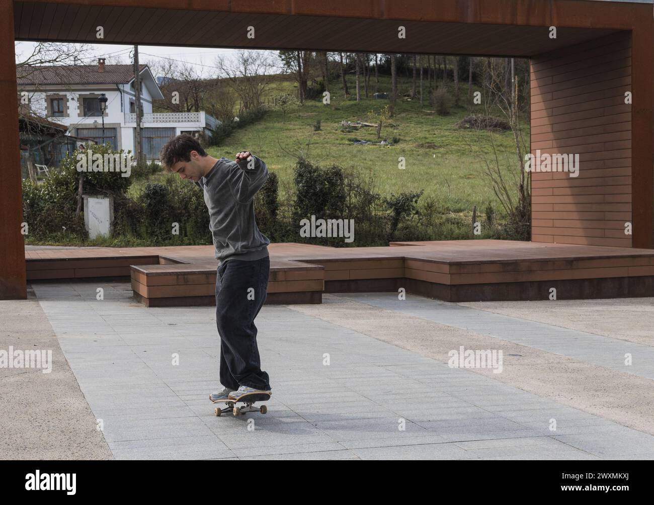 A skater is caught mid-trick, demonstrating his skills in a public ...