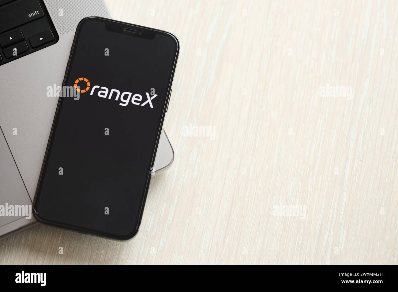KYIV, UKRAINE - MARCH 15, 2024 OrangeX logo on iPhone display screen on ...