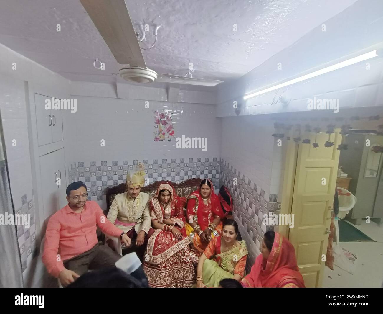 Family gathering in a small room during an Indian wedding function ...