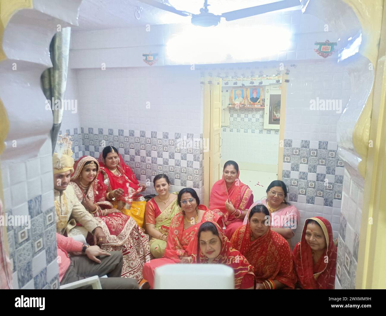 Family gathering in a small room during an Indian wedding function ...