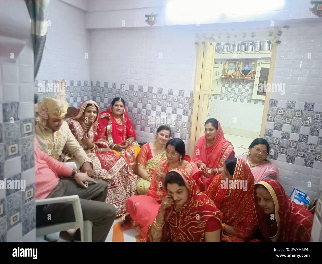 Family gathering in a small room during an Indian wedding function ...