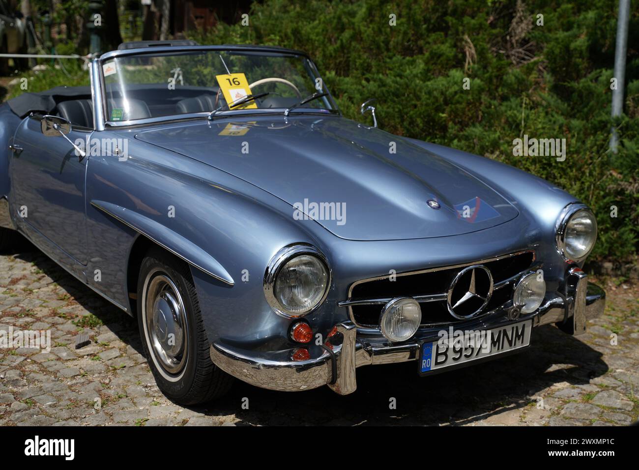 A metallic blue Mercedes-Benz 190SL parked on a cobblestone road Stock ...