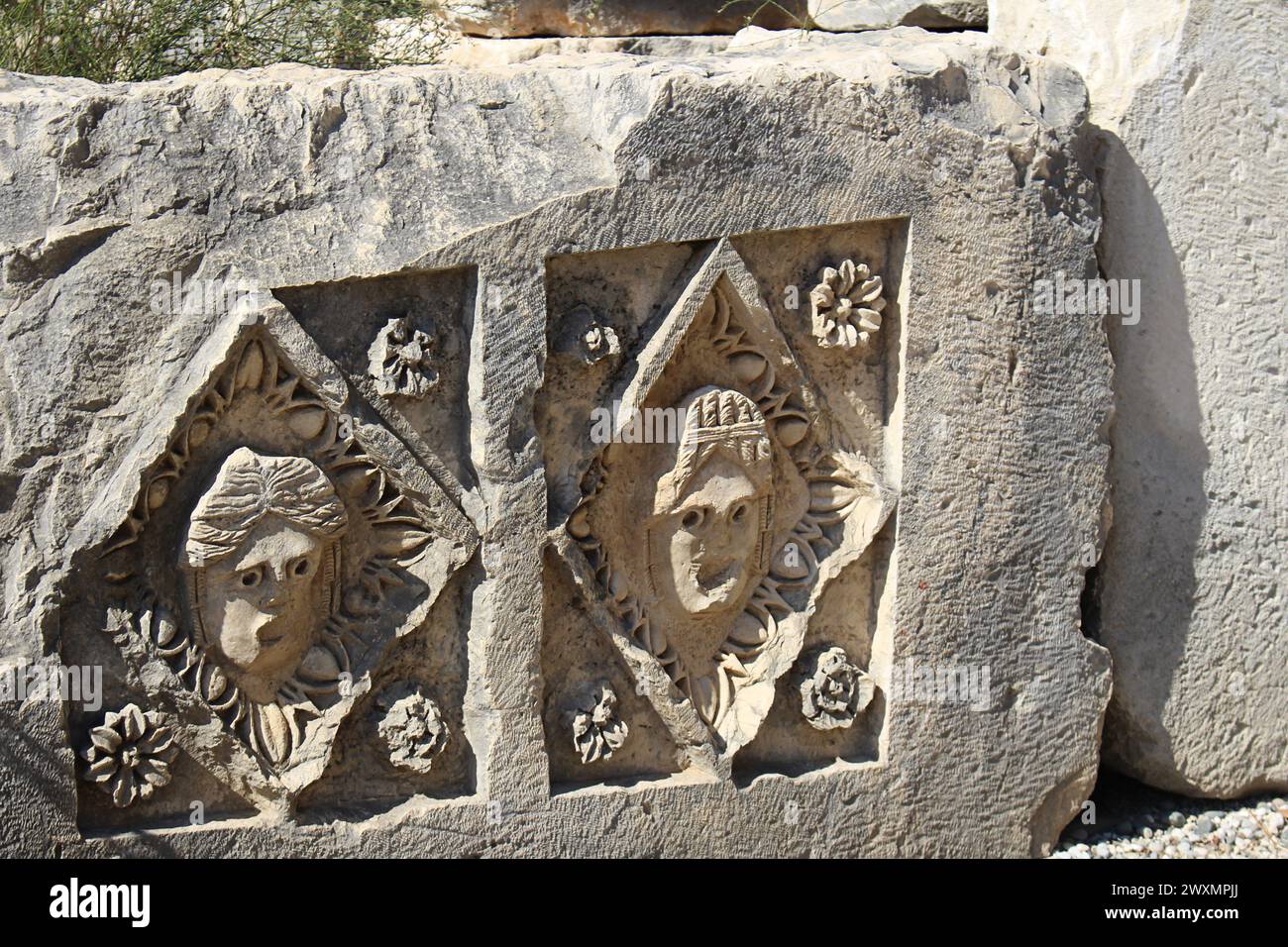 Historical stone bas-relief with carved faces in ancient city of Myra ...