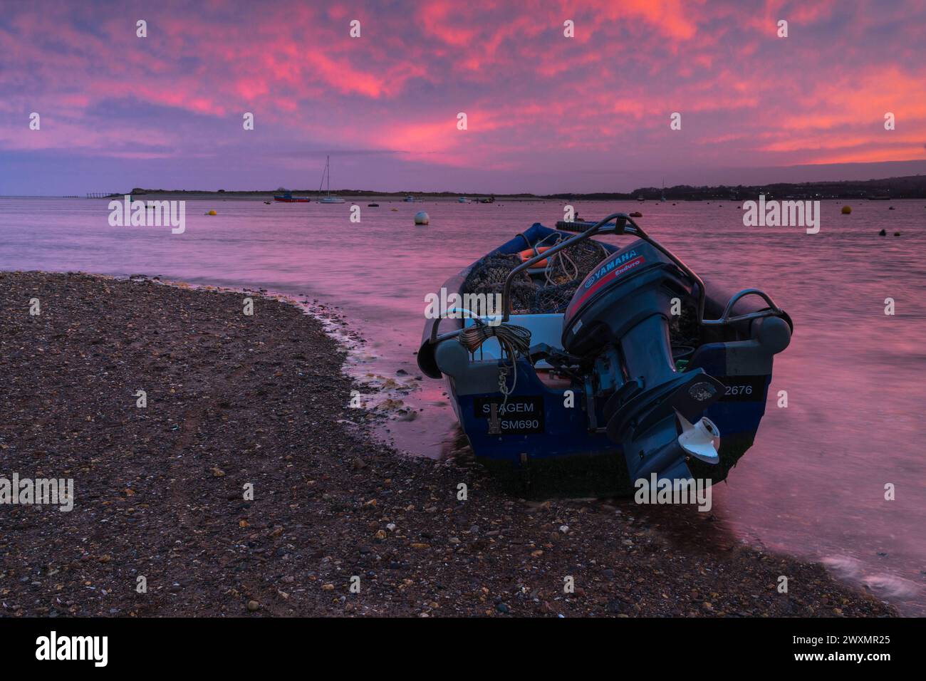 Modern day fishing boat with Lobster pots moored up beneath the setting ...